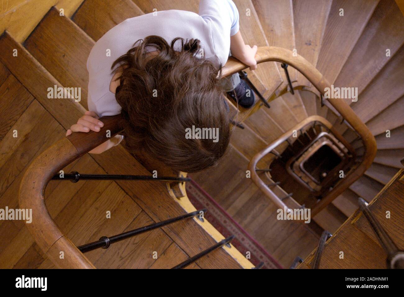 Vertigo. Woman suffering from vertigo. She is gripping a bannister ...