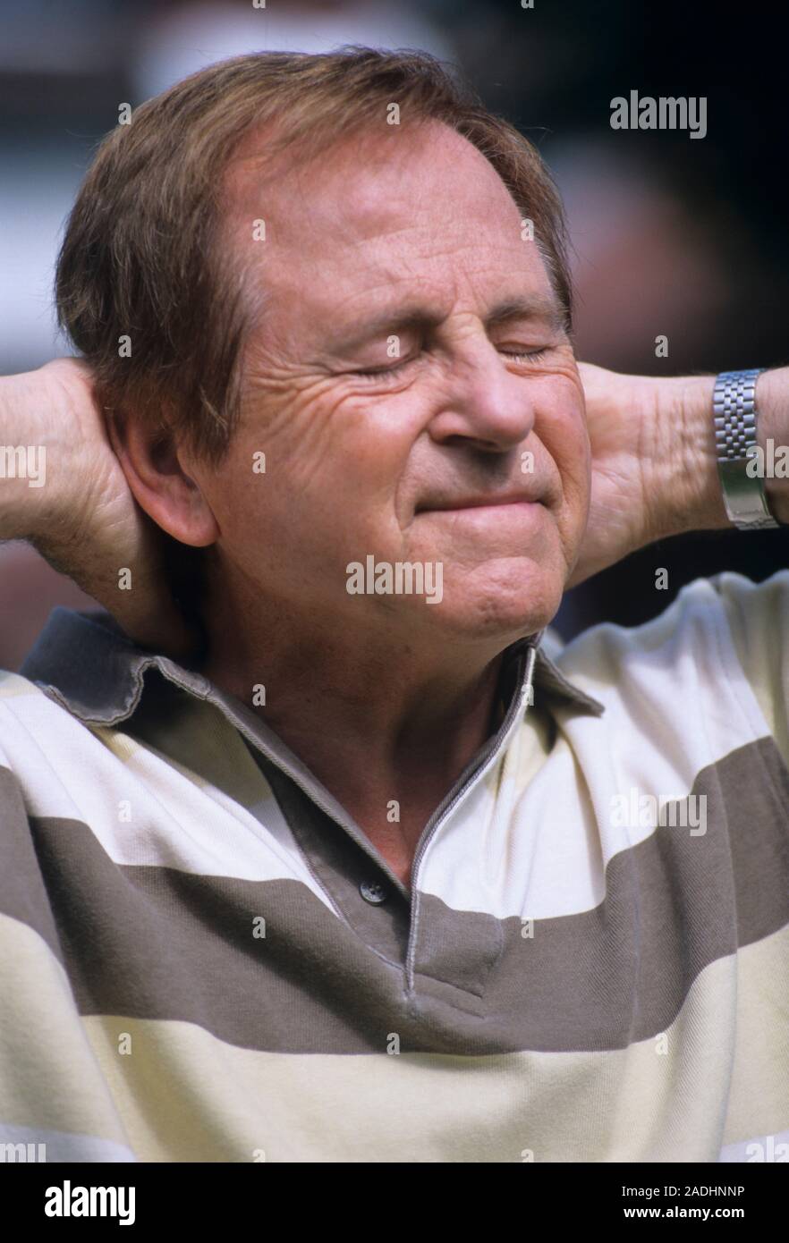 MODEL RELEASED. Stressed man stretching his neck and back muscles to ...