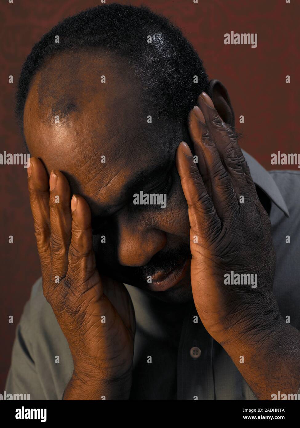MODEL RELEASED. Depressed man cupping his face in his hands Stock Photo ...