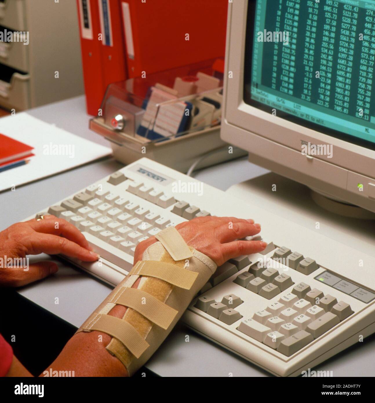 Computer operator wearing a special supporting wrist brace in order to ...