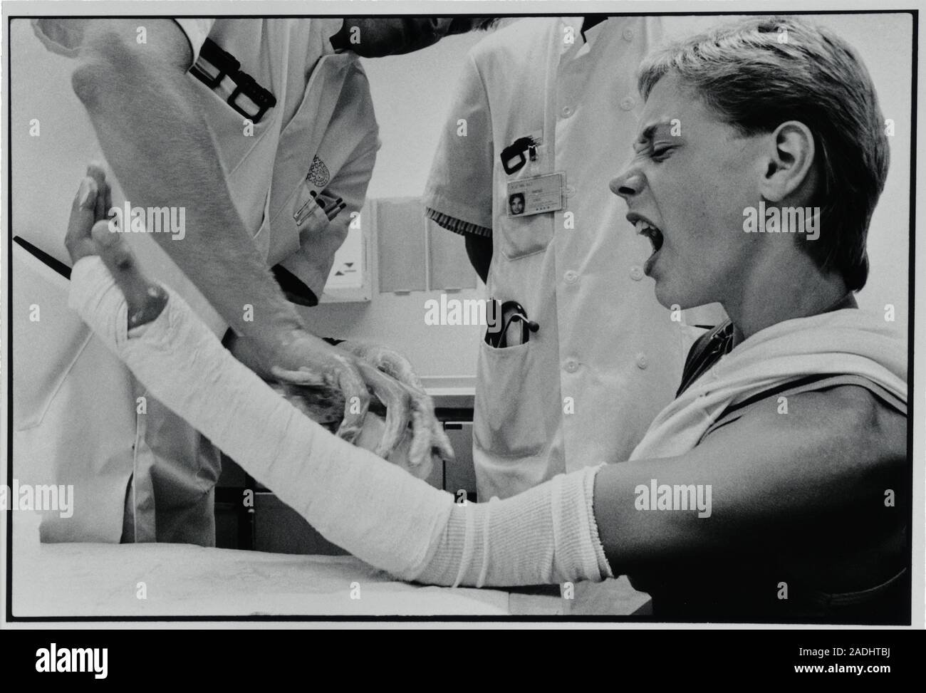 Plaster cast. Boy expresses pain as medical staff put the finishing ...