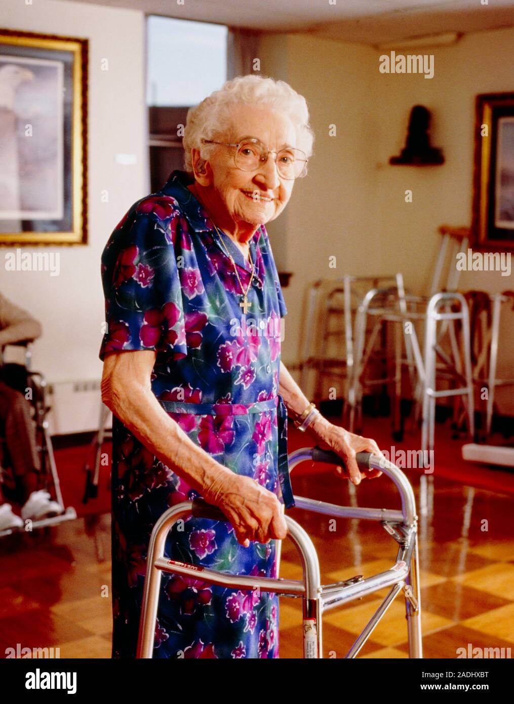 Walking frame. Elderly woman uses a walking frame in an old age home ...