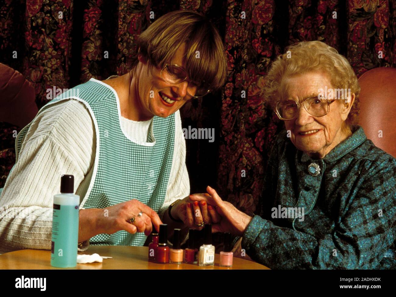 Geriatric care. Care worker painting an elderly woman's nails Stock ...