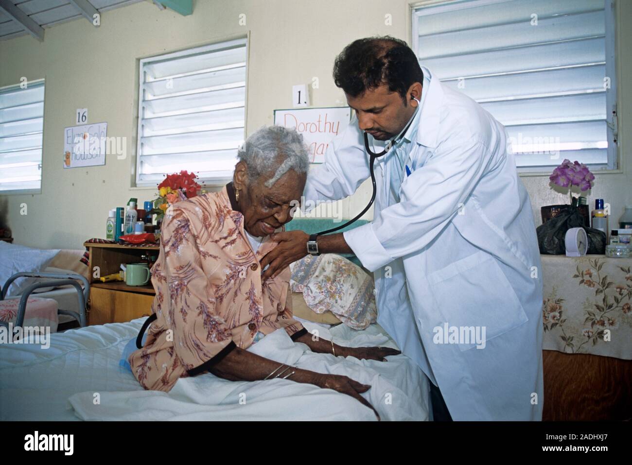 MODEL RELEASED. Geriatric care. Doctor using a stethoscope to examine ...