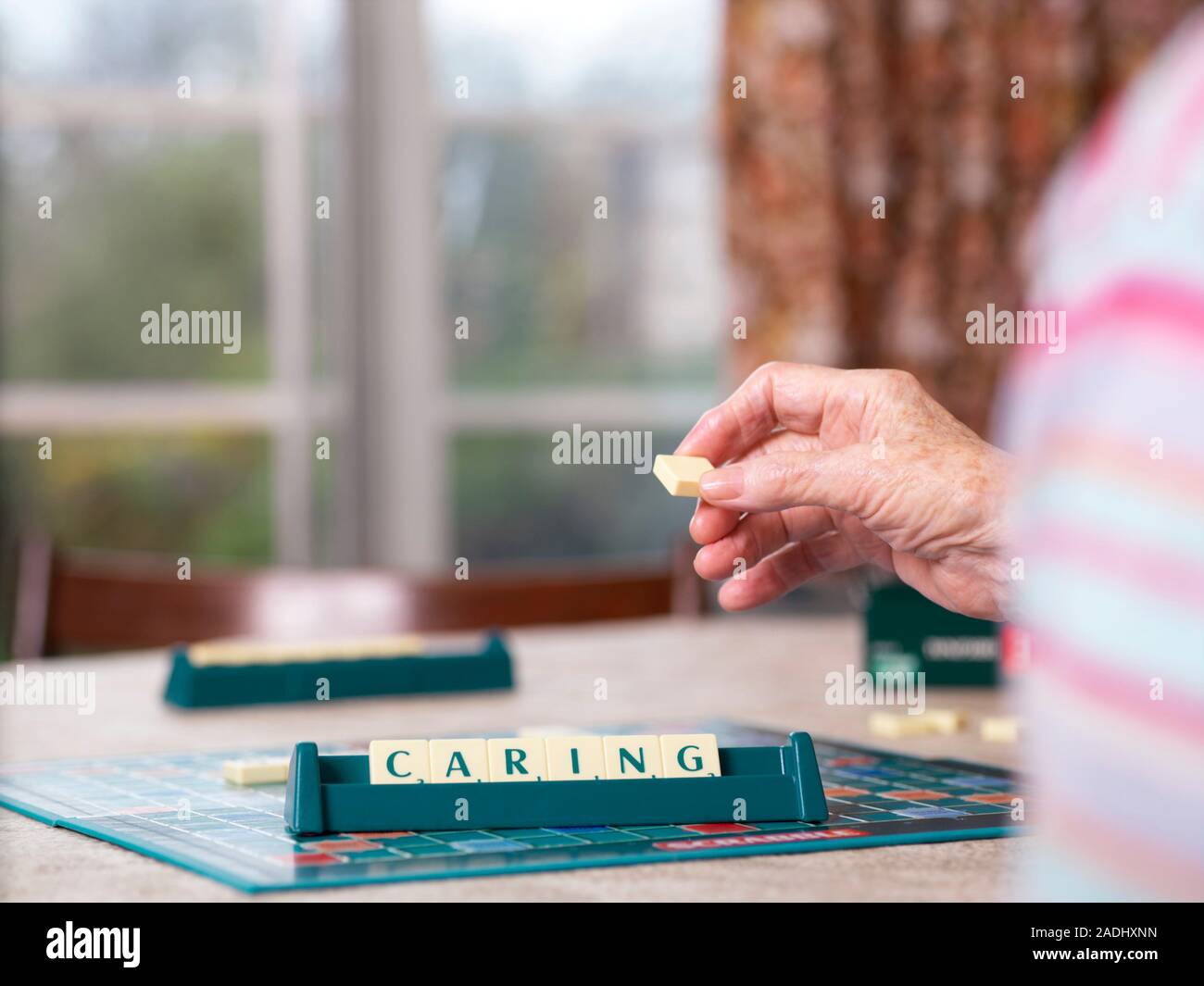 MODEL RELEASED. Geriatric care. Hand of a 83 year old woman playing ...