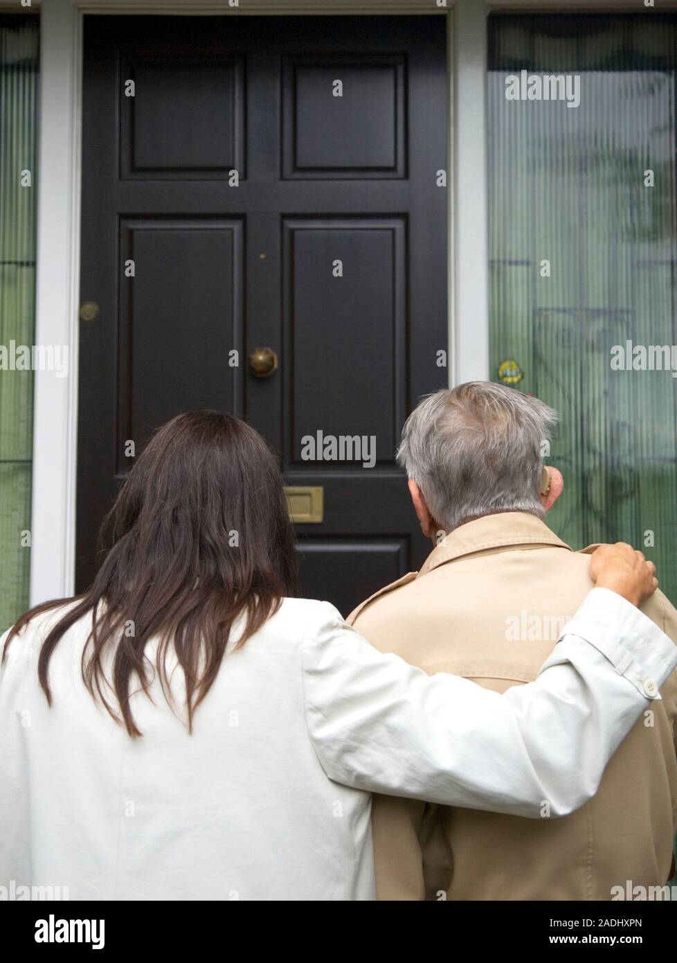 Geriatric care. Woman helping an elderly man to his door Stock Photo ...