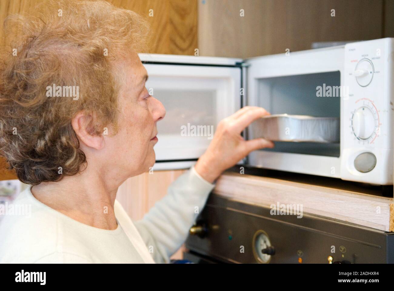 MODEL RELEASED. Elderly woman using a microwave oven Stock Photo - Alamy