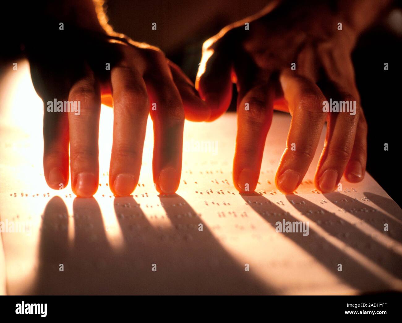 Braille. Hands of a blind person move over a sheet written in braille ...