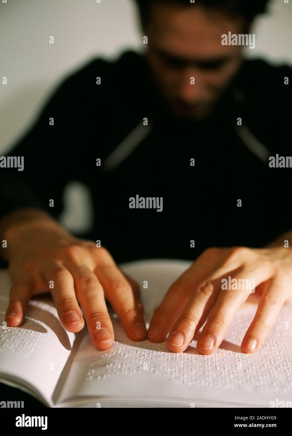 Braille. Blind man moving his fingers across a page from a book written ...