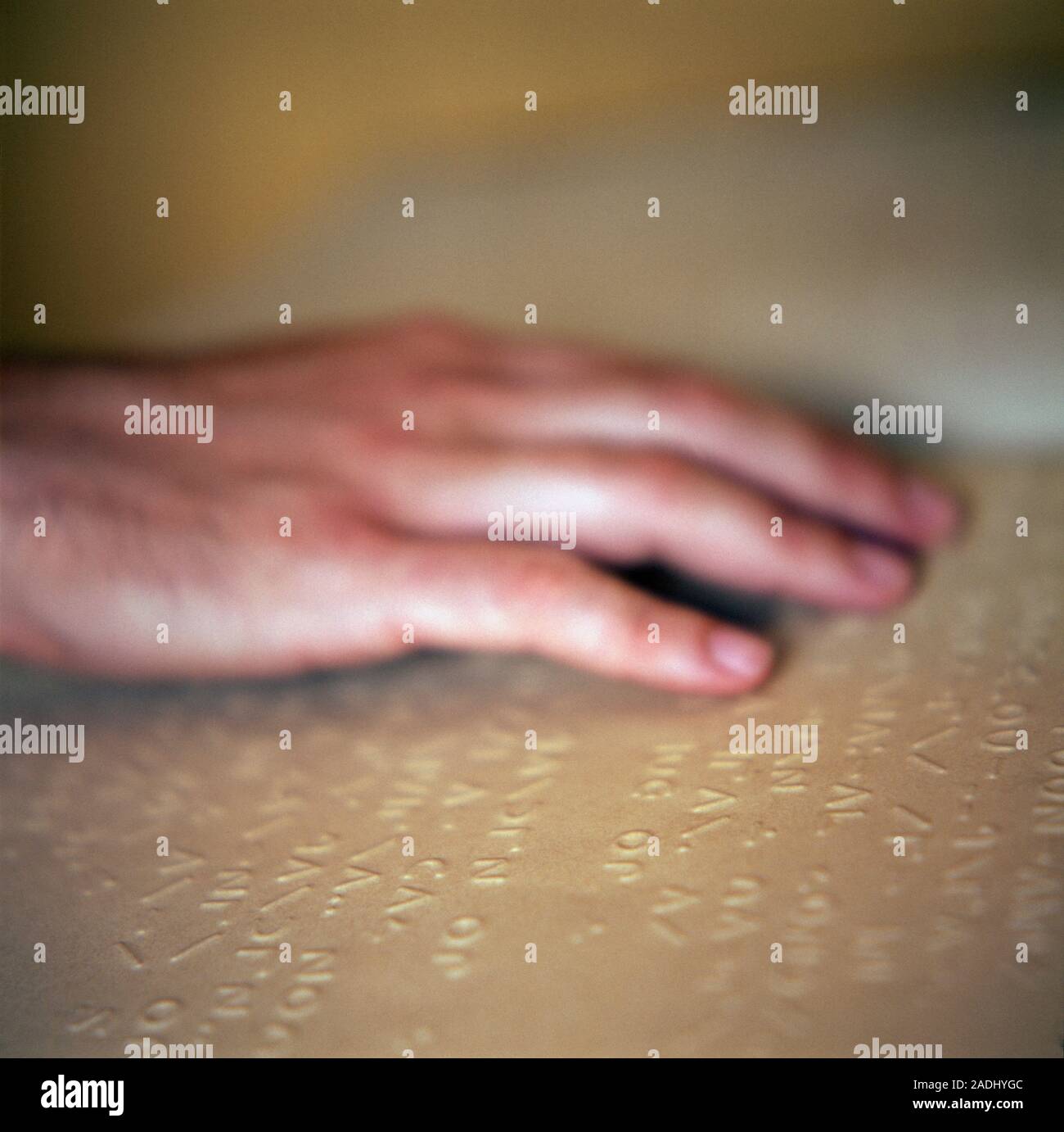 Moon Braille. Hand of a blind person running over text written in Moon ...
