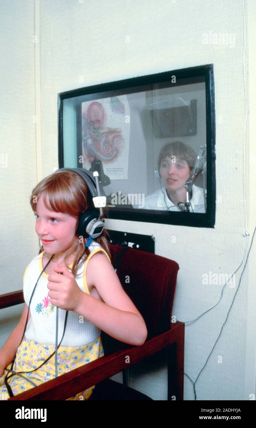 Hearing test. Young girl with hearing difficulties being tested by an ...