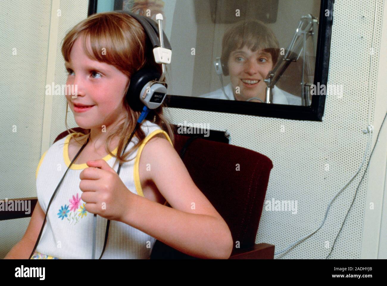 Hearing test. Young girl with hearing difficulties being tested by an ...