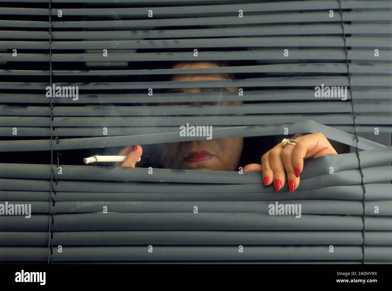 Woman smoking tobacco. A depressed looking woman smokes a cigarette ...