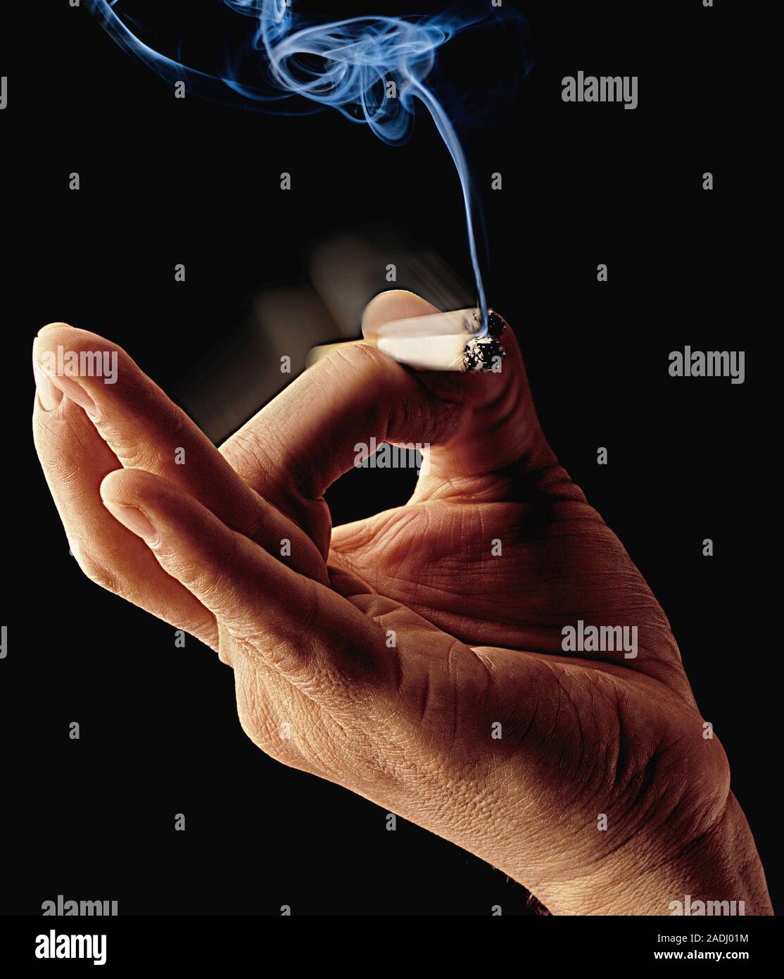 Smoking. Hand about to flick a lit cigarette. Cigarettes contain the ...