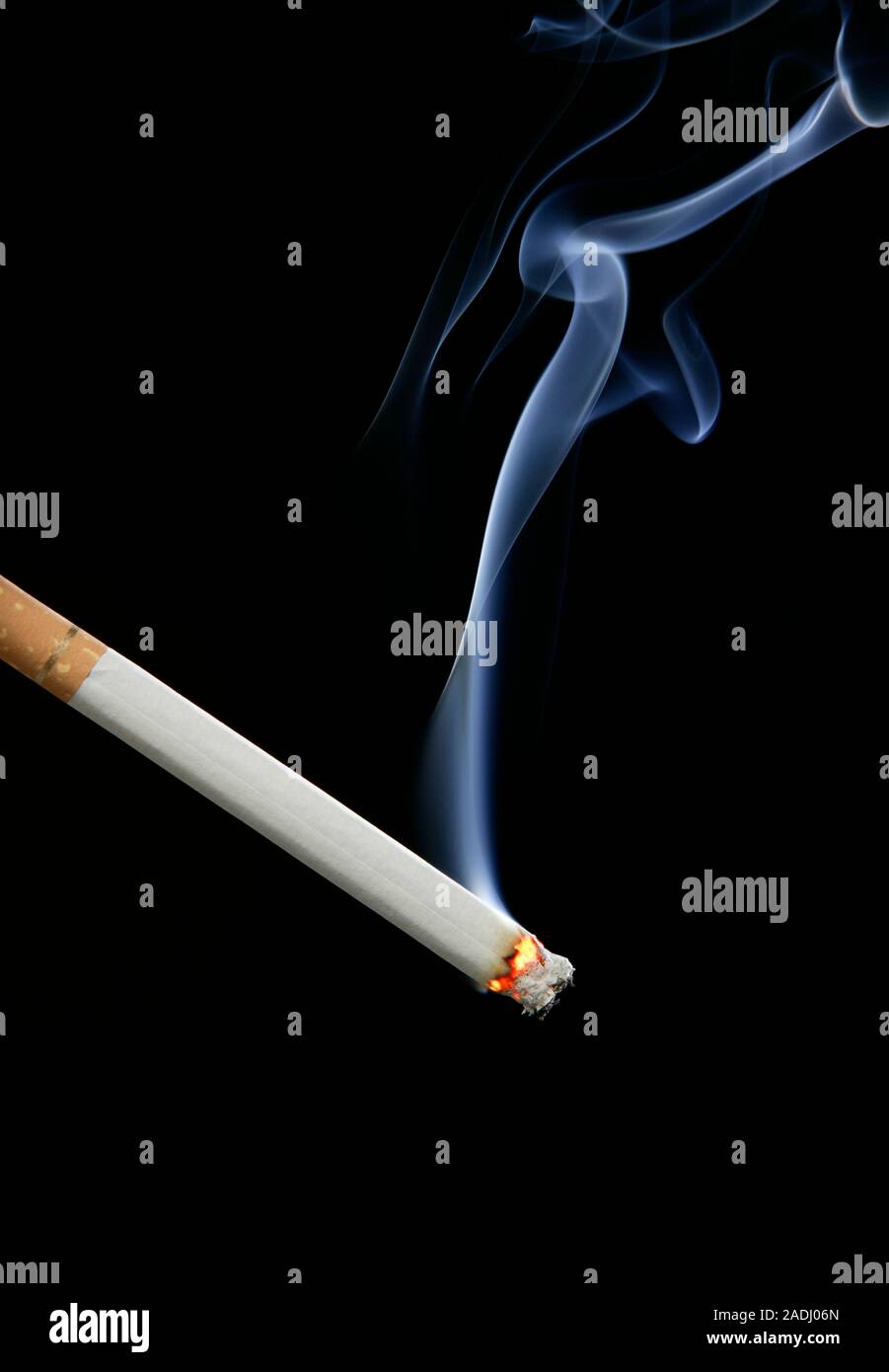 Lit cigarette. Tobacco cigarettes contain the stimulant drug nicotine ...