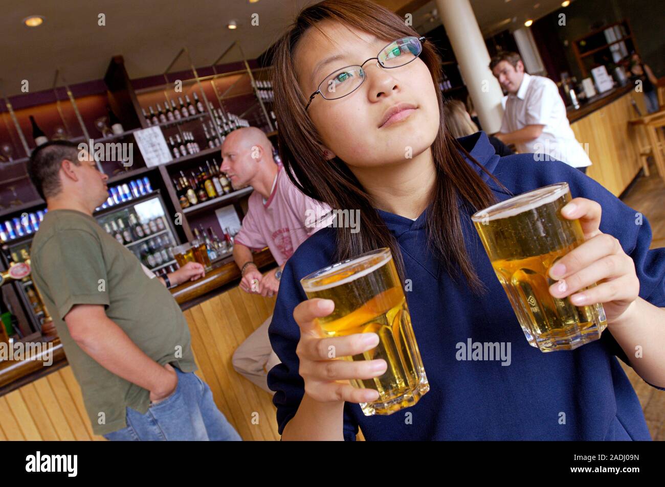 Alcoholic drinks. Woman carrying two beers in a pub Stock Photo - Alamy