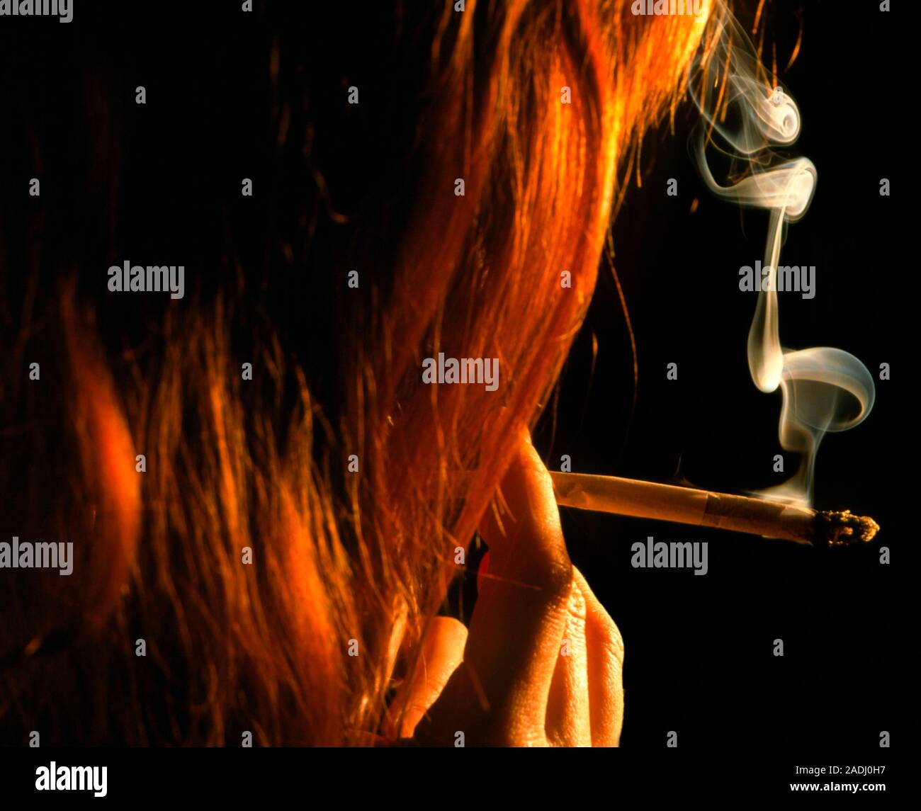 Marijuana. Drug user smokes a marijuana cigarette (called a joint or ...