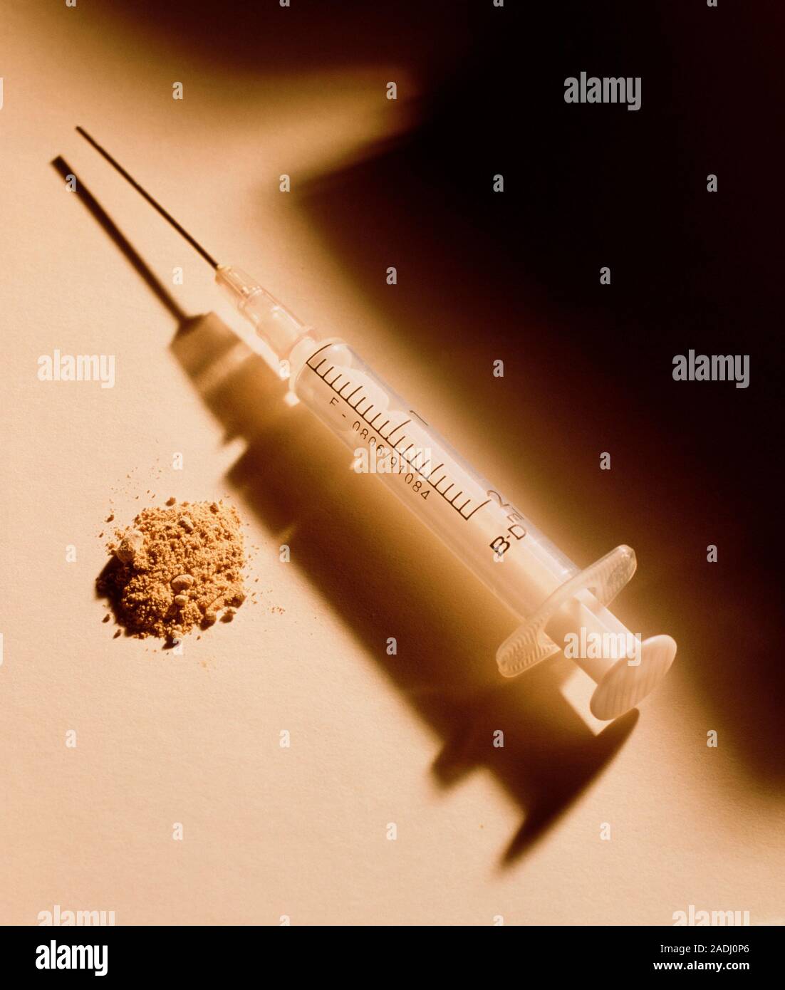 Heroin equipment. Hypodermic needle and syringe with a pile of heroin ...