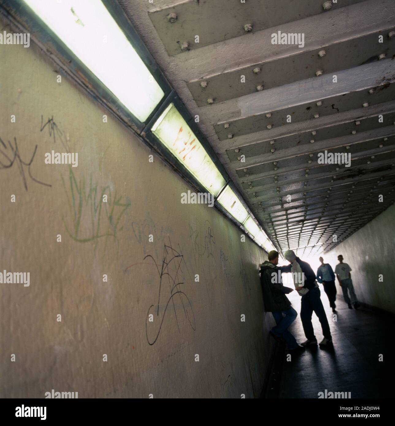 Drug dealing. Two men (standing next to the wall) covertly exchanging ...