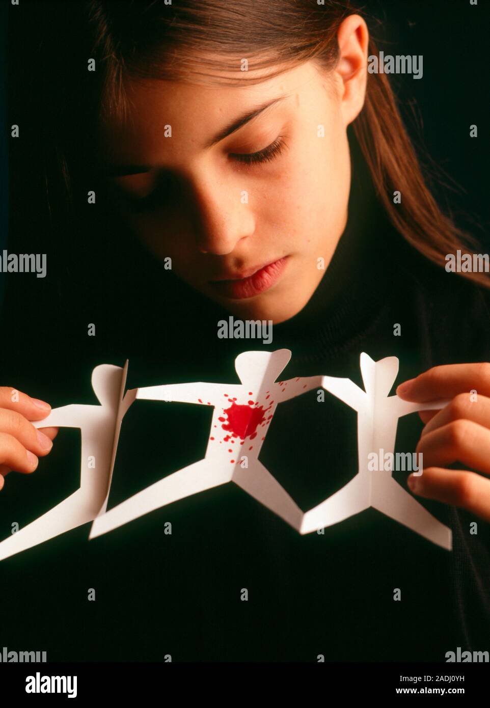 Post-traumatic stress. Conceptual image of a girl holding a paper chain ...