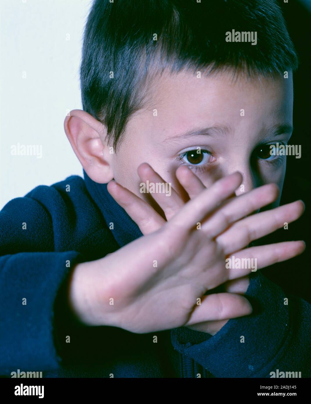 Child abuse. Young boy cowering behind his hands from an attacker Stock ...