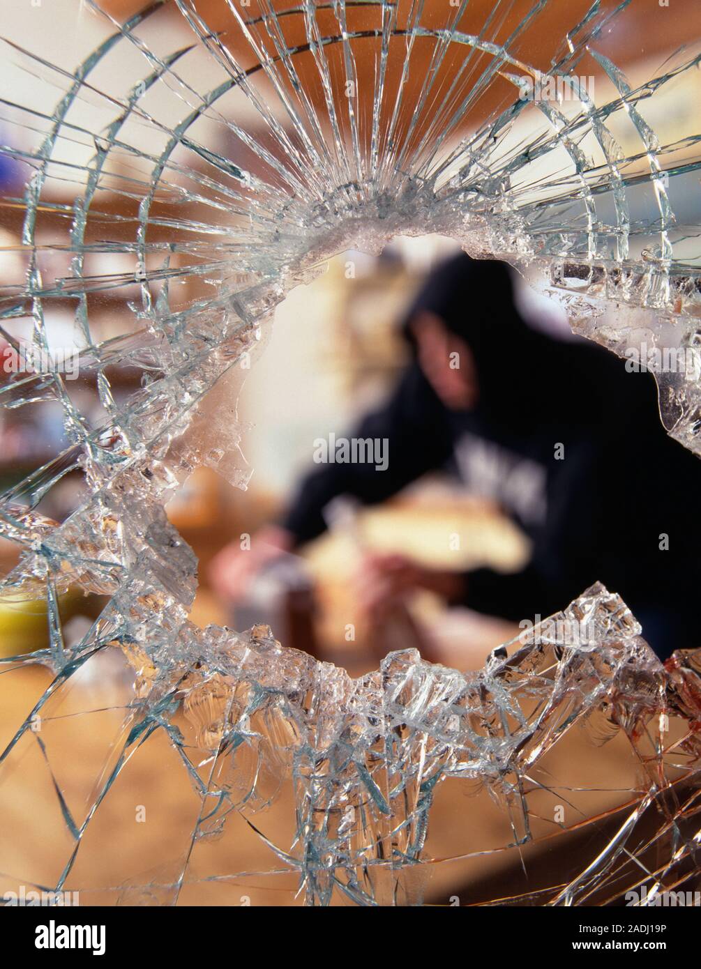 Burglar in a house viewed through a broken window, which he used to ...