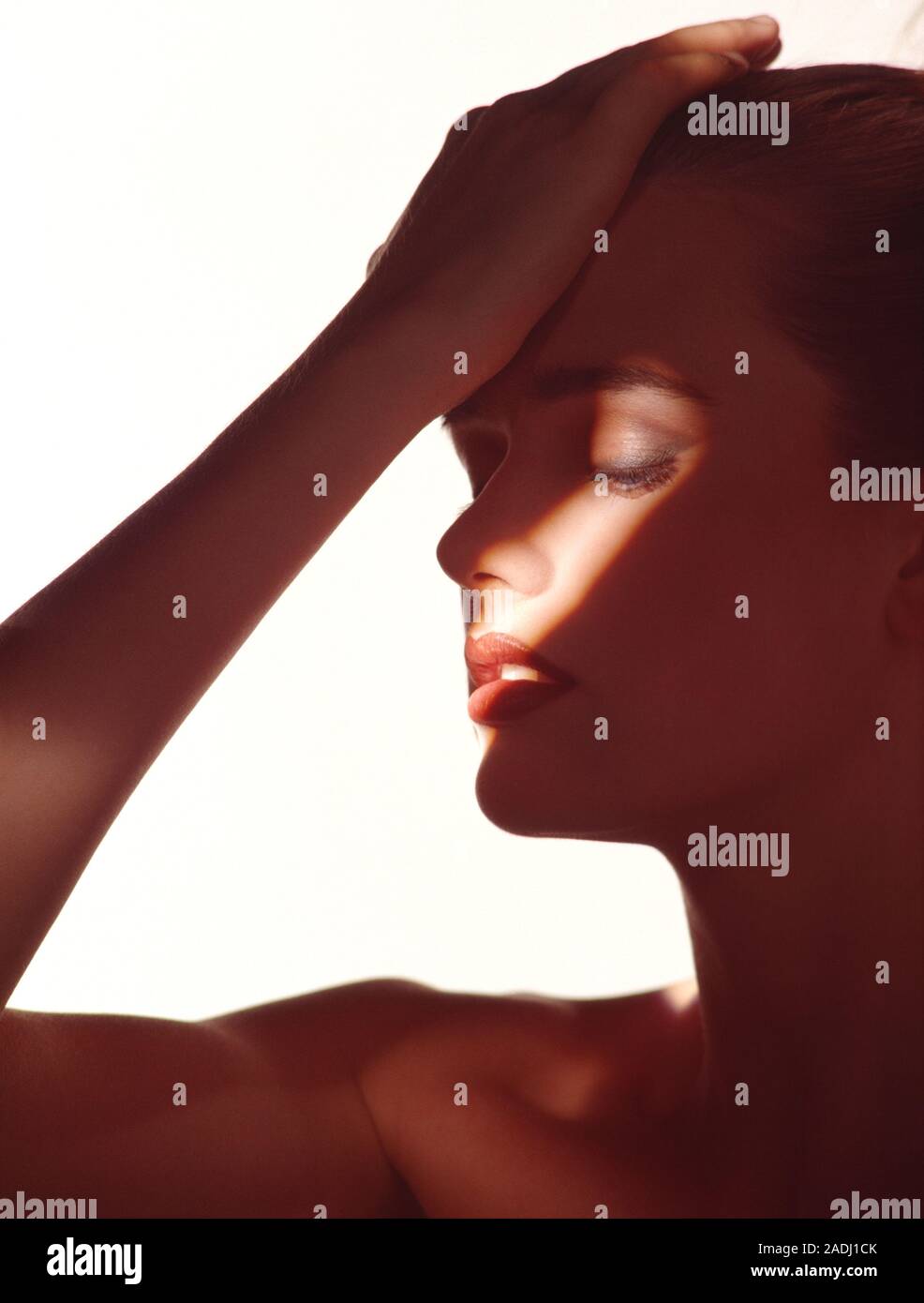 MODEL RELEASED. Woman with headache, seen in silhouette Stock Photo - Alamy