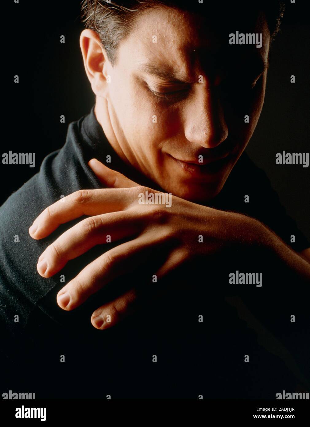 Shoulder pain. View of a man holding his shoulder while suffering from ...