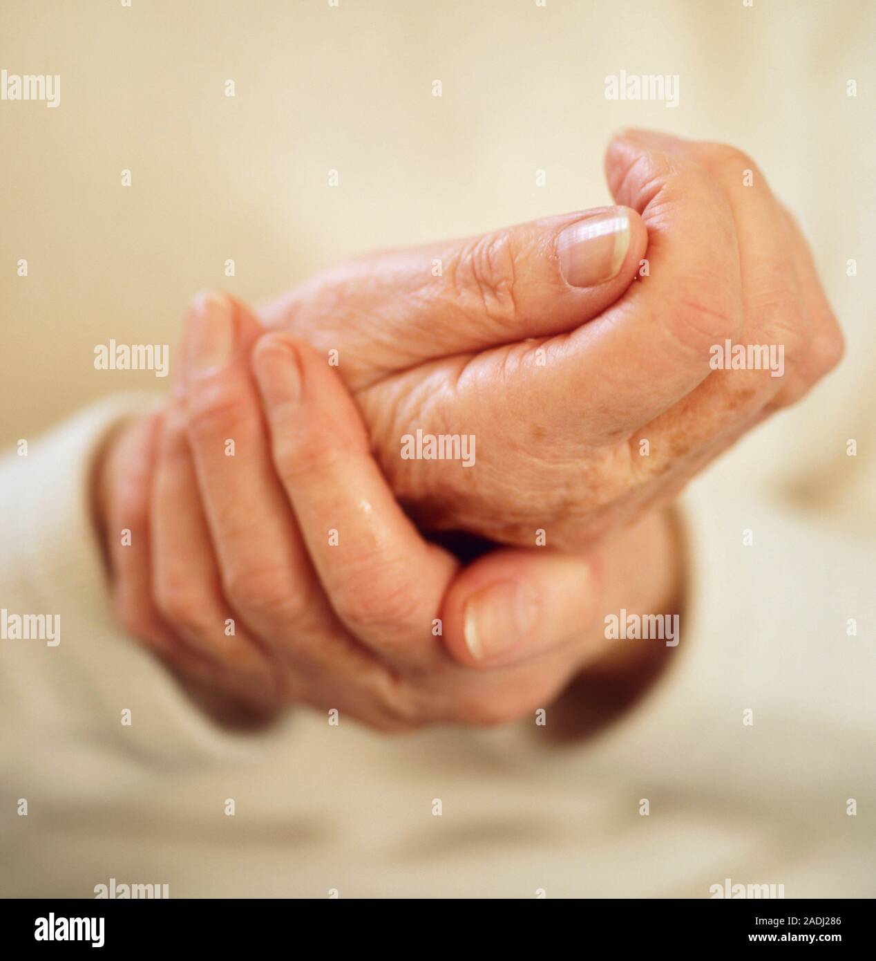 Arthritic hands. Elderly woman rubbing her arthritic sore hand ...