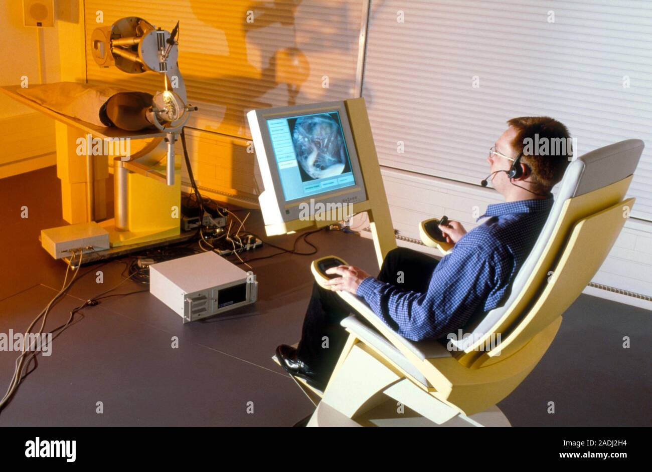 Robot-aided surgery. Technician carrying out simulated robot-aided ...