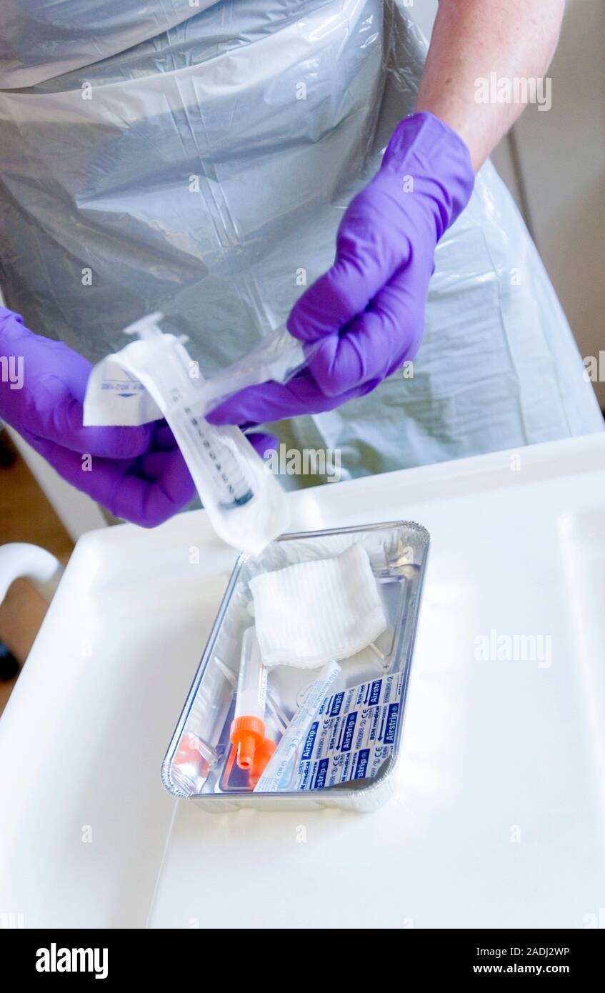Syringe. Nurse preparing a syringe for taking a blood sample or giving ...