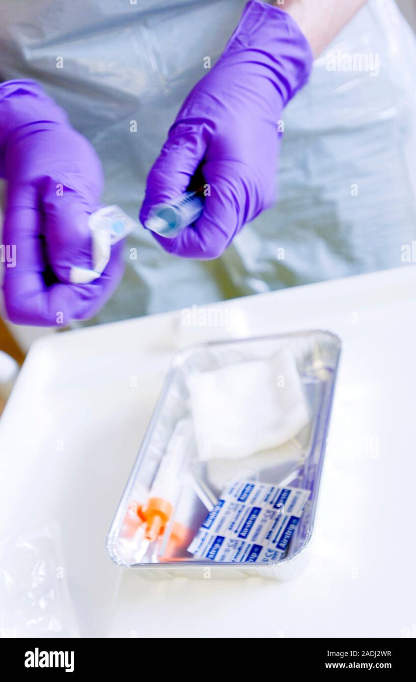 Syringe. Nurse preparing a syringe for taking a blood sample or giving ...