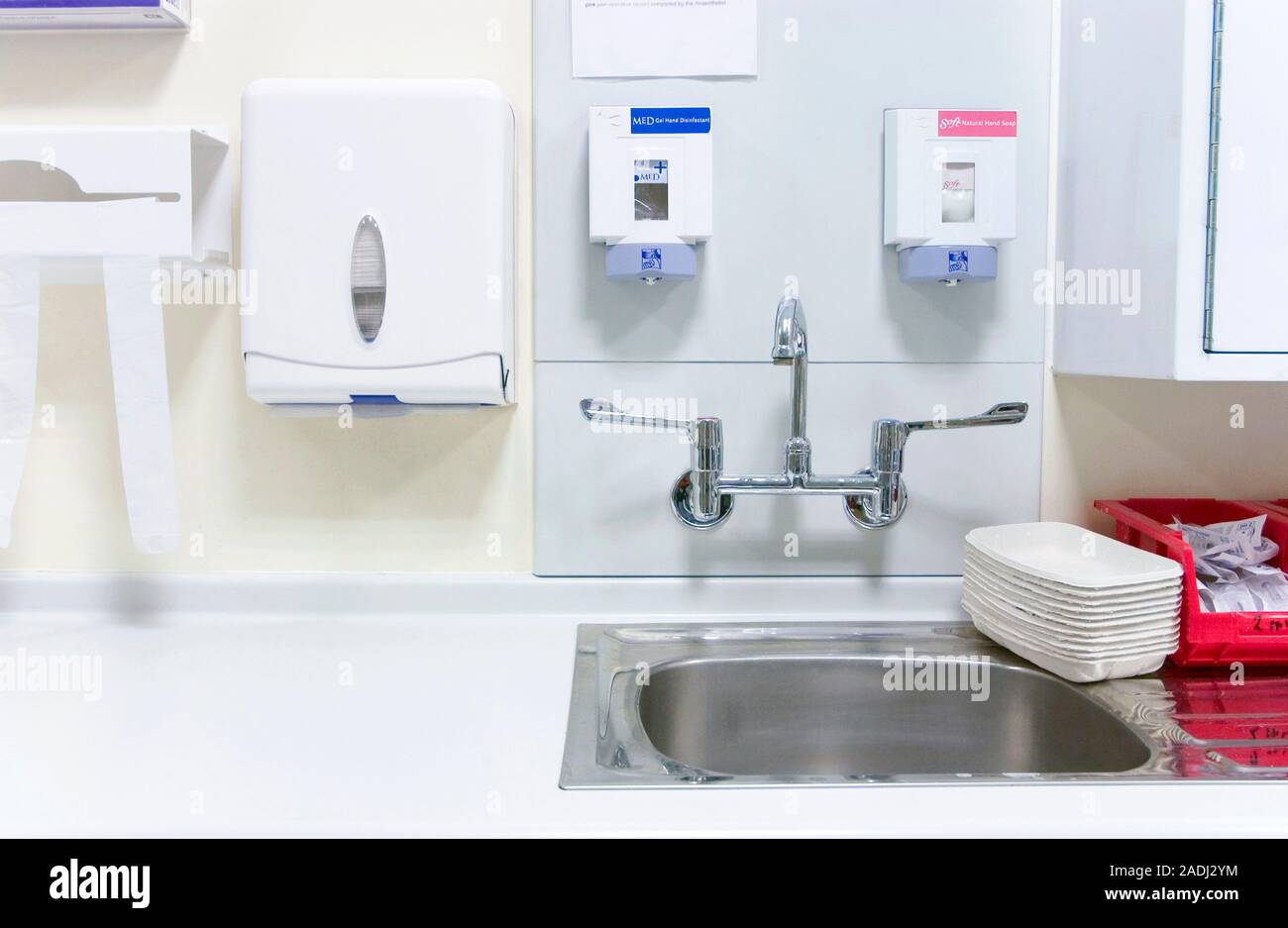 Hospital sink with dispensers for disinfectant, soap, hand towels and ...