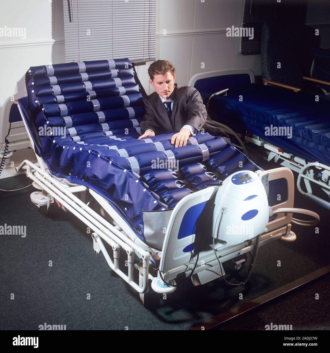 Hospital bed technology. Man adjusting an inflatable mattress that is ...