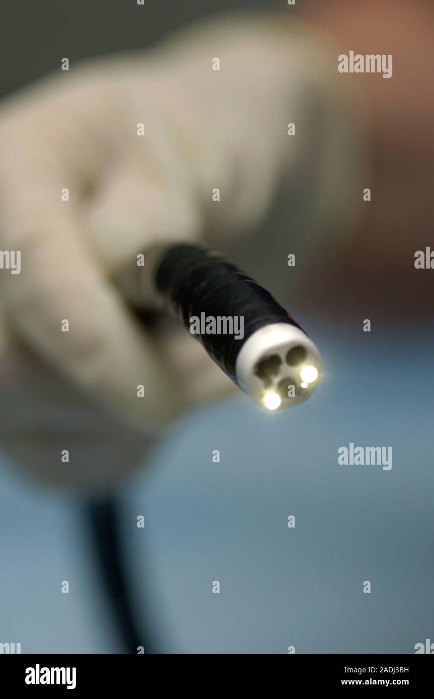 Endoscope. Gloved hand holding the tip of an endoscope. An endoscope is ...