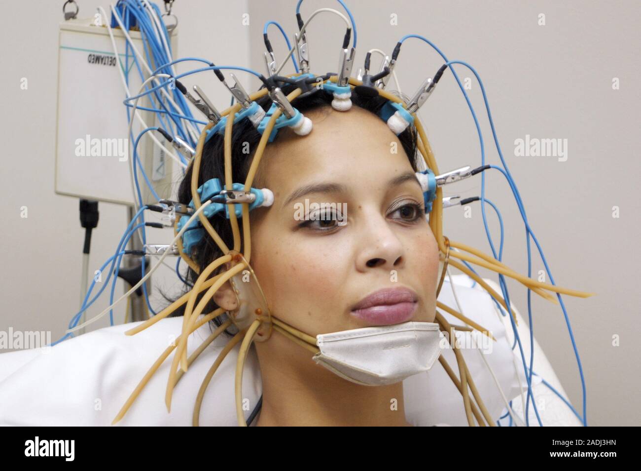 EEG examination. 27-year-old woman undergoing an electroencephalograph (EEG) examination ...