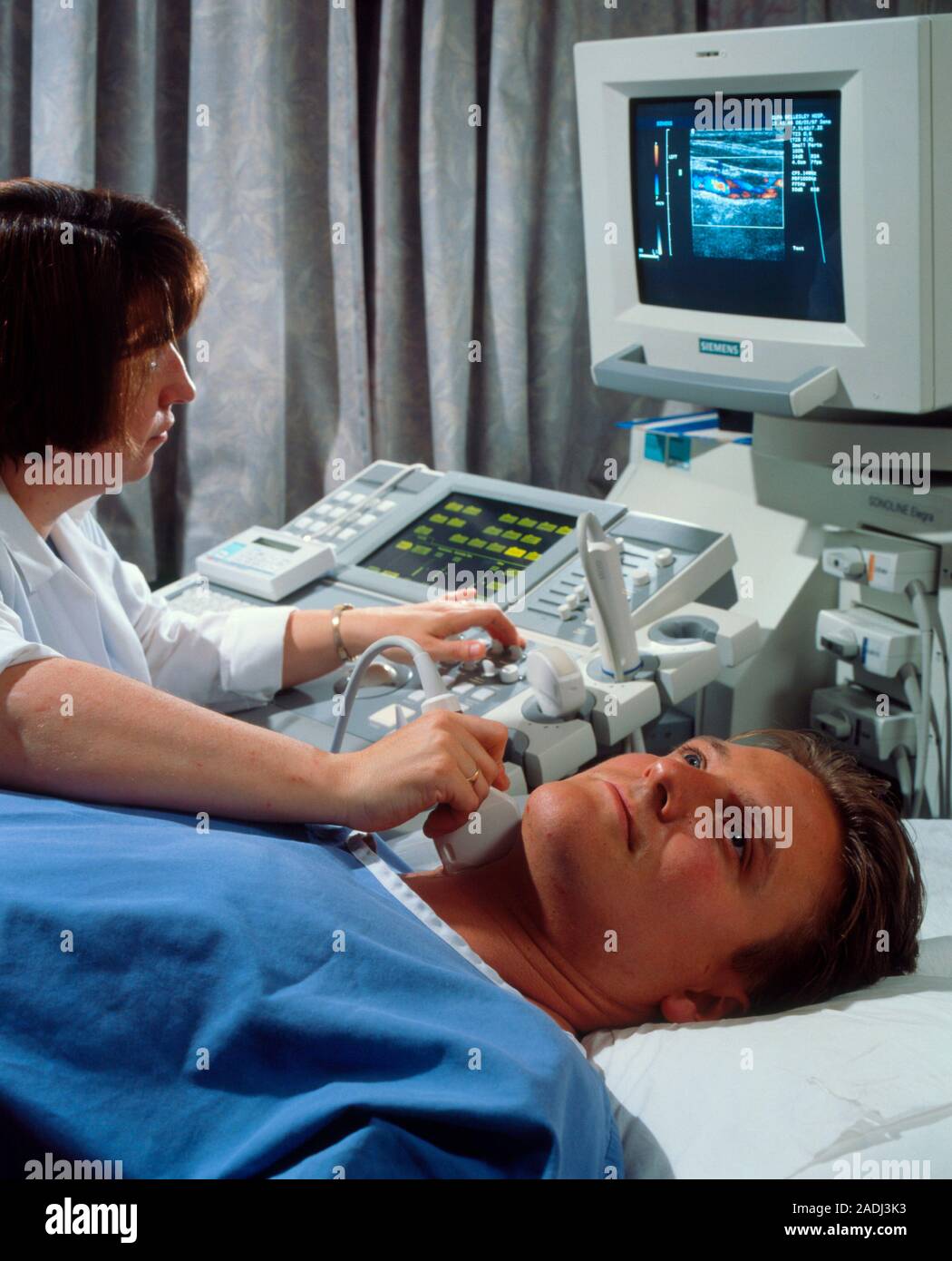 Doppler ultrasound scan of neck. Male patient has the carotid artery in ...