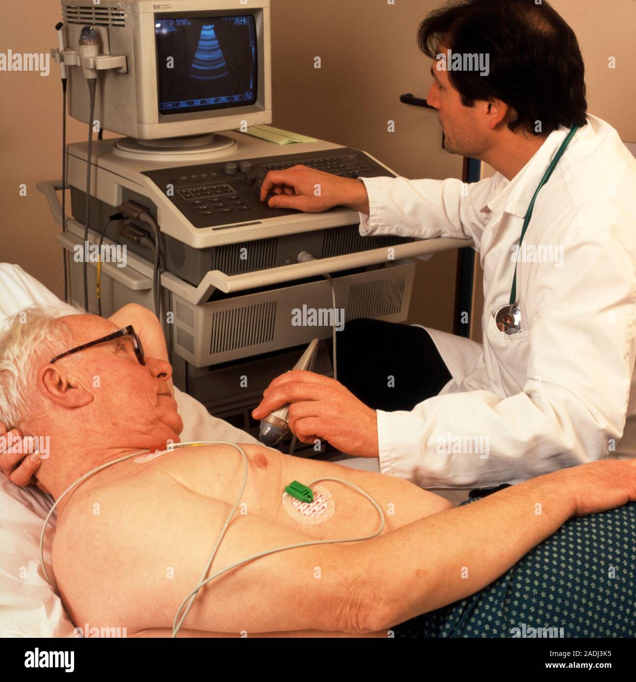 Heart ultrasound scan. Elderly male patient undergoing an ultrasound ...