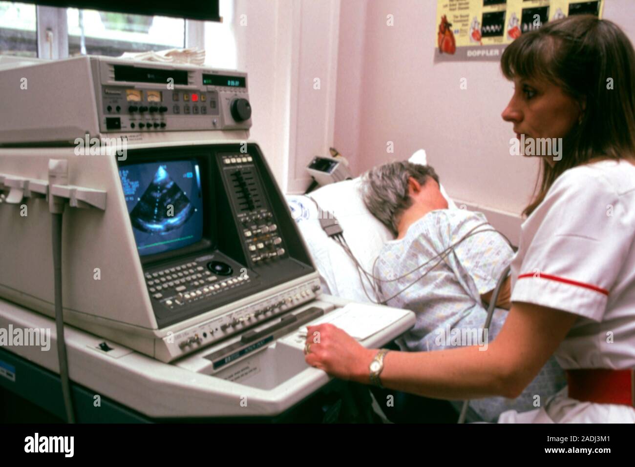 Echocardiography. Female member of medical staff carrying out a doppler ...