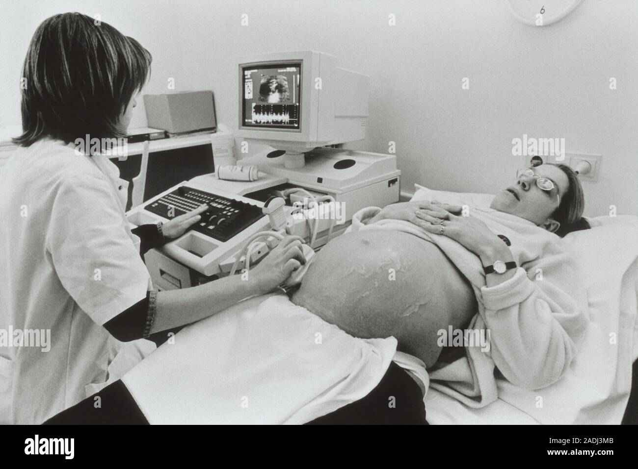 Pregnancy ultrasound. Pregnant woman undergoing an ultrasound scan. The ...