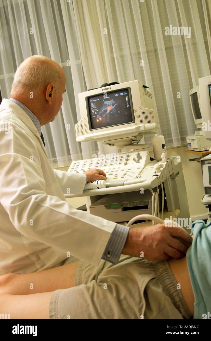 Doppler ultrasound. Doctor holding an ultrasound transducer next to a ...