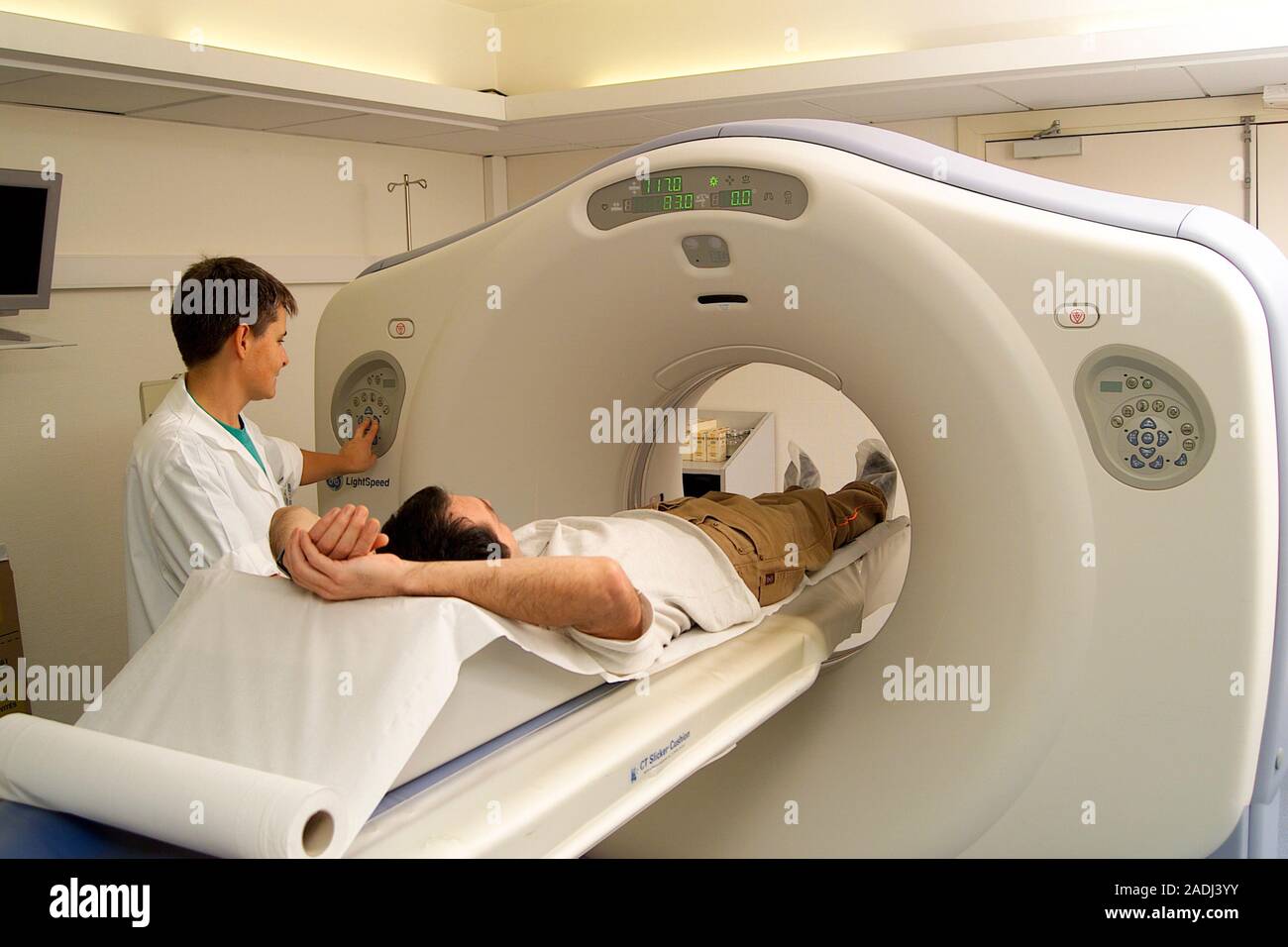 CT scanning. Radiologist preparing a patient for a computed tomography ...