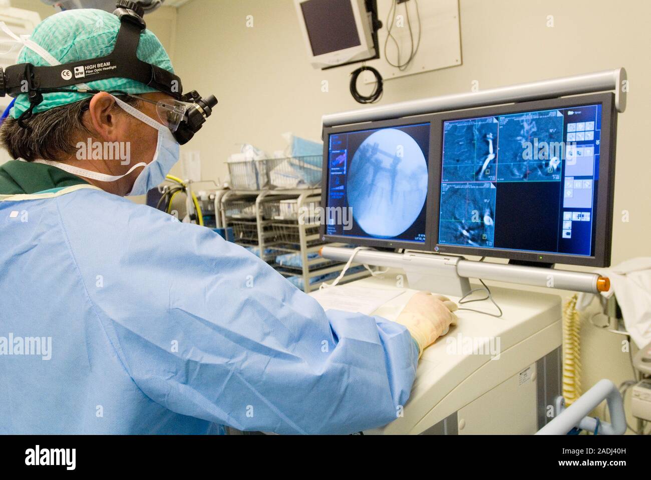 3D CT scanning during spinal surgery. Surgeon analysing a patient's ...