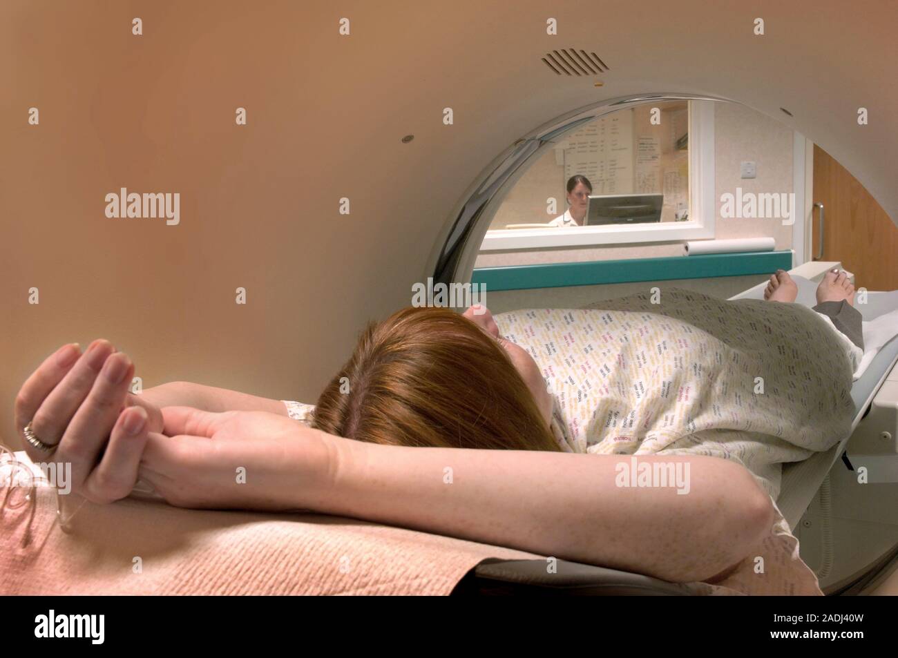 CT scanning. Patient undergoing a CT scan while the radiographer ...
