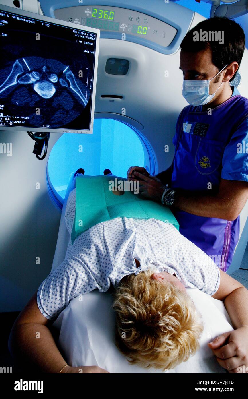 CT scanning. Surgeon using CT scan images as a guide during a procedure ...