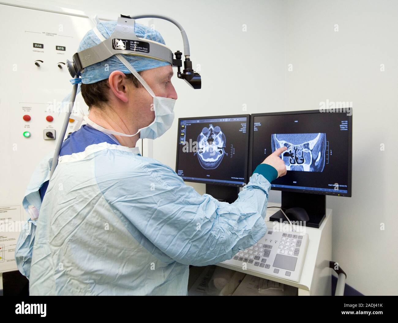 Surgeon studying computed tomography (CT) scans of the head of a ...