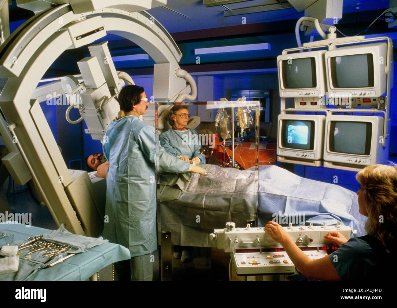 Cardiac catheterisation. Surgeons performing a cardiac catheterisation ...