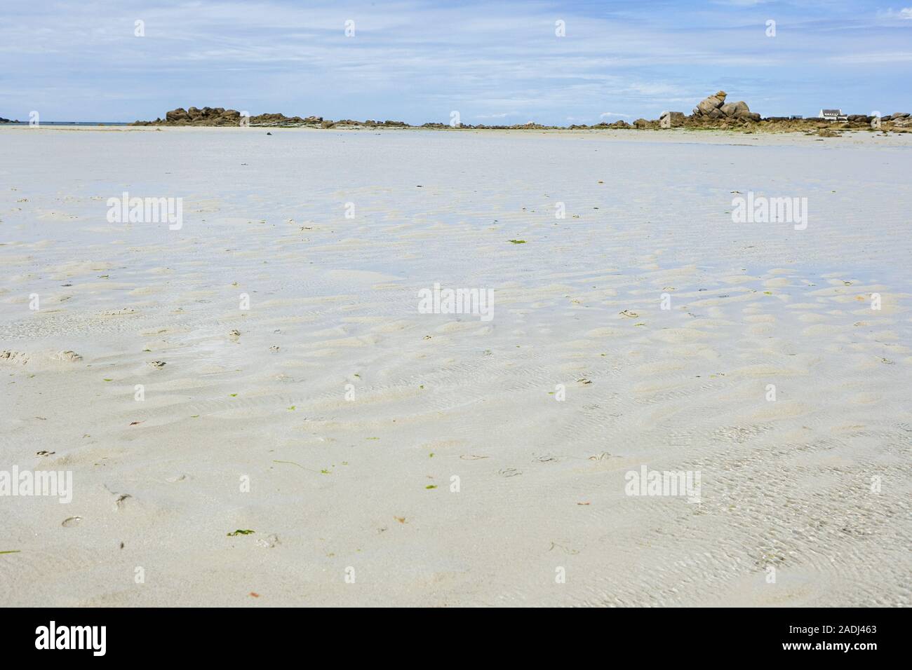 Ebb at a beach at the coastline of Brittany, blue sky with clouds Stock ...