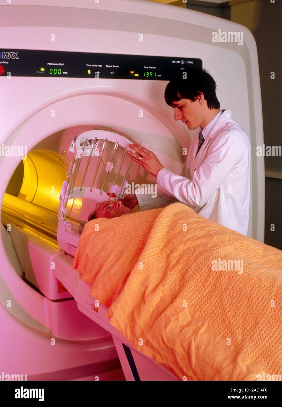 Radiographer preparing a patient for a magnetic resonance imaging (MRI ...