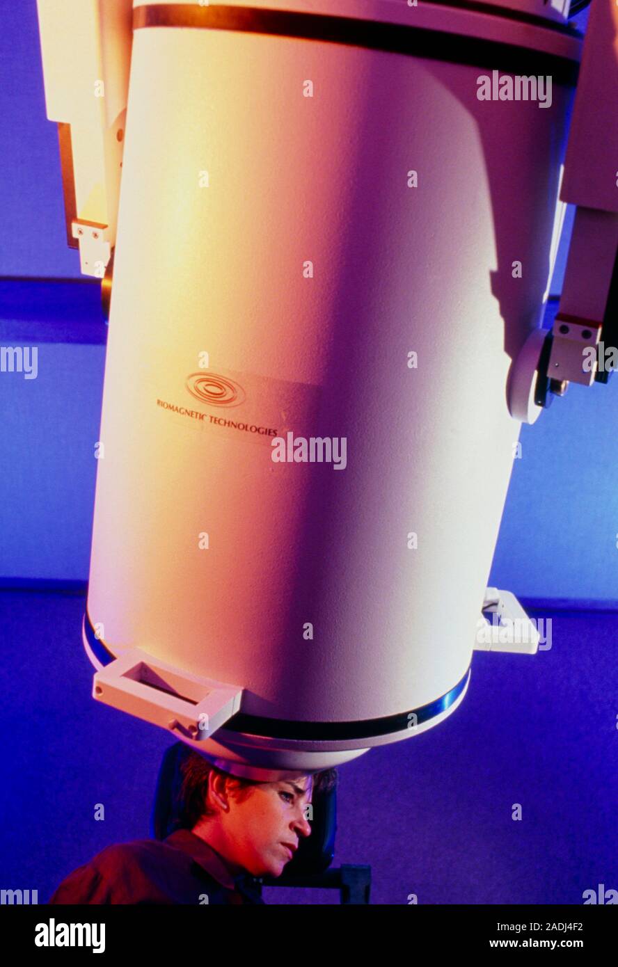 Magnetoencephalography (MEG). Woman undergoing a brain scan with a ...